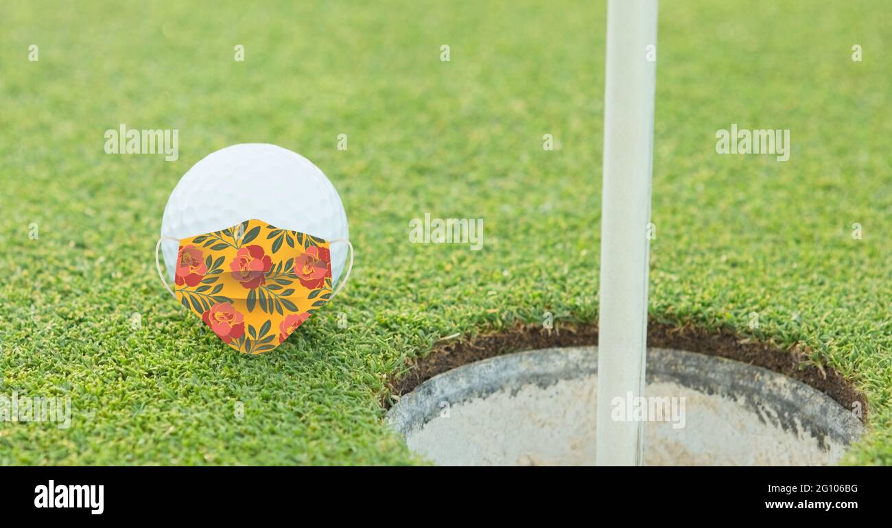 Composition of golf ball with face mask on grass with copy space Stock ...