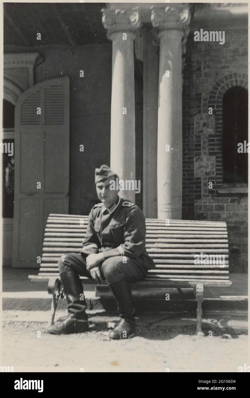 Wehrmacht soldier sitting on a wooden bench. A Wehrmacht soldier is ...