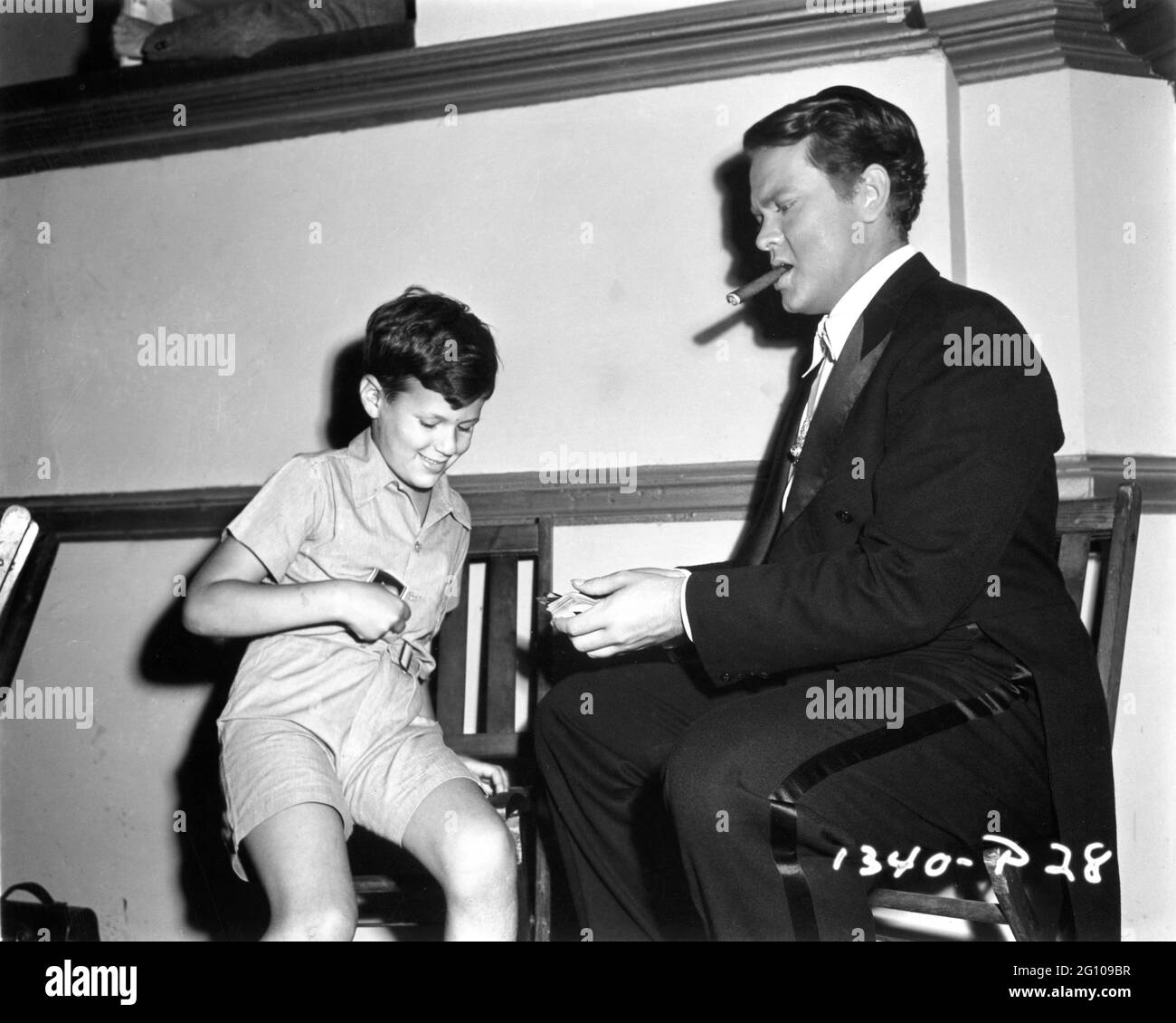 ORSON WELLES on set candid performing a magic card trick for a young ...