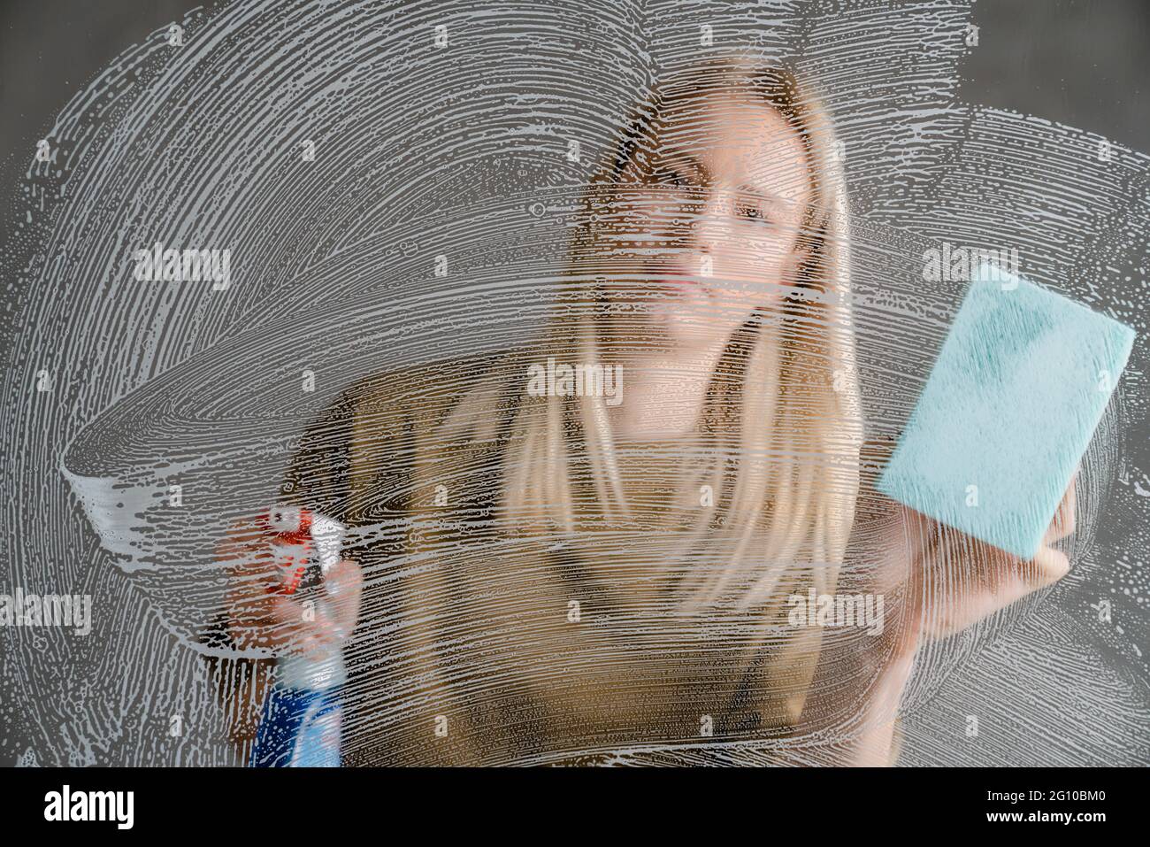 Blonde european woman washing glass with cleaning product and sponge ...