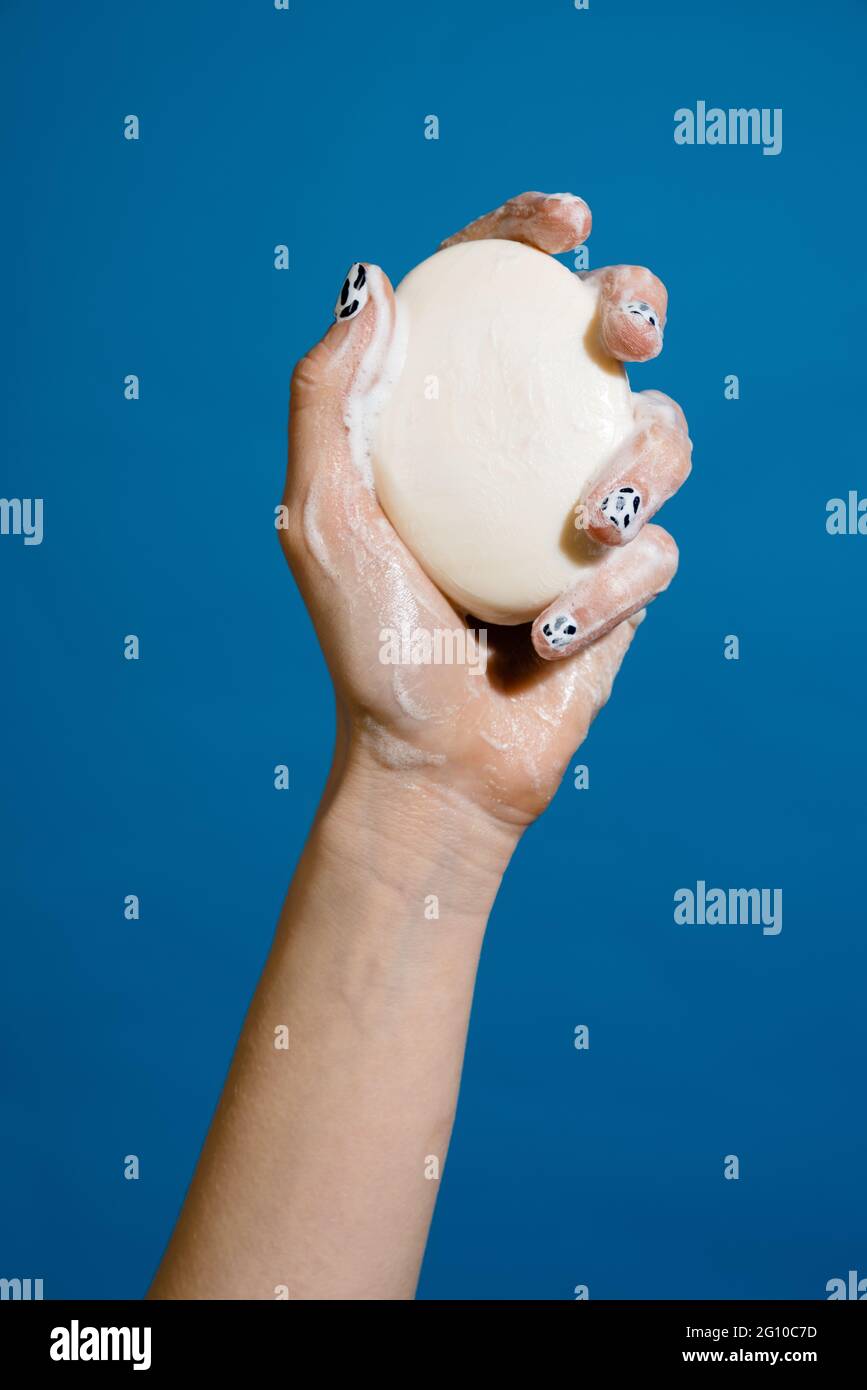 Closeup photo of hand and soap isolated over blue wall Stock Photo - Alamy
