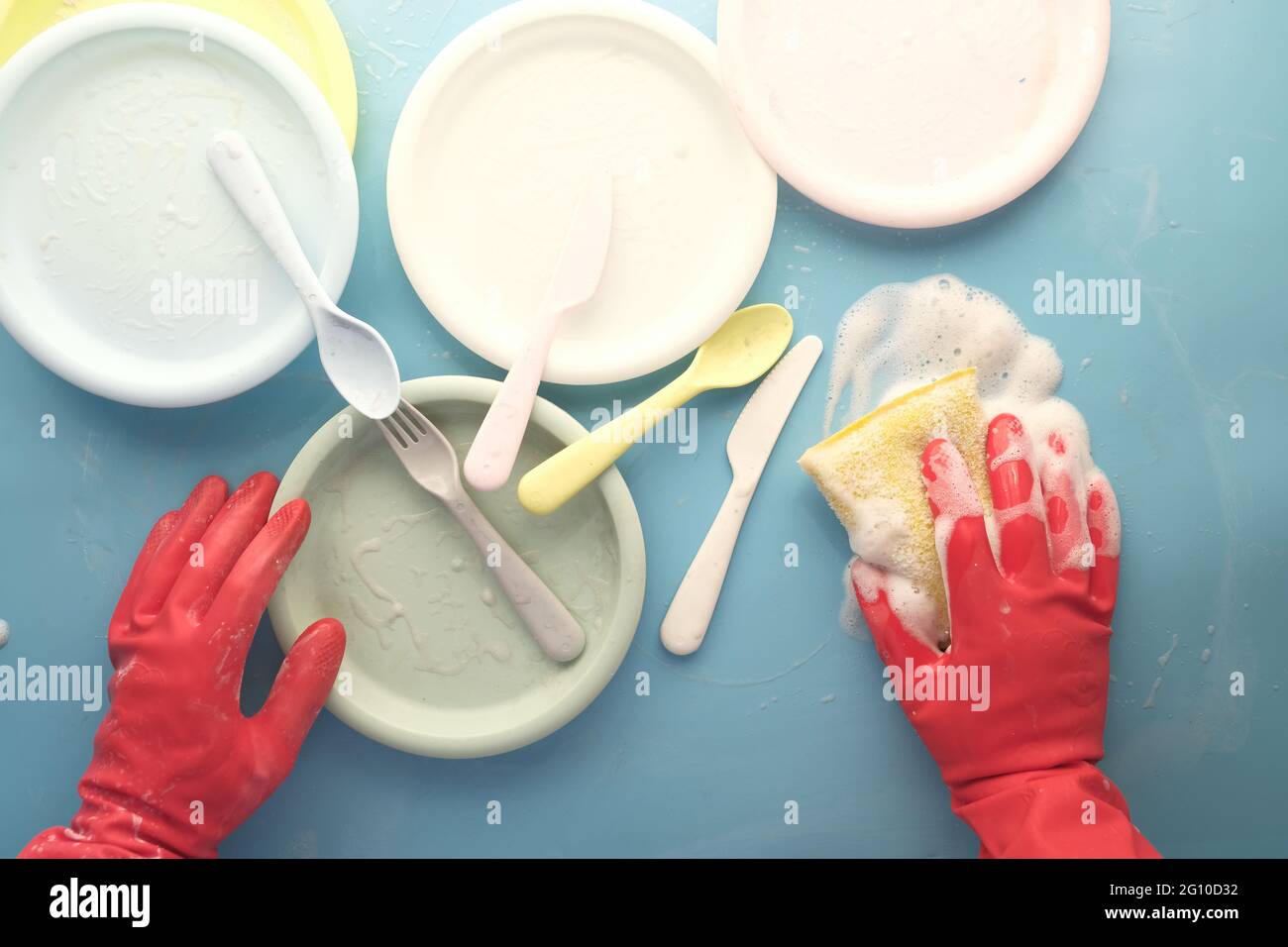 sponge , rubber gloves and colorful plate on blue Stock Photo - Alamy