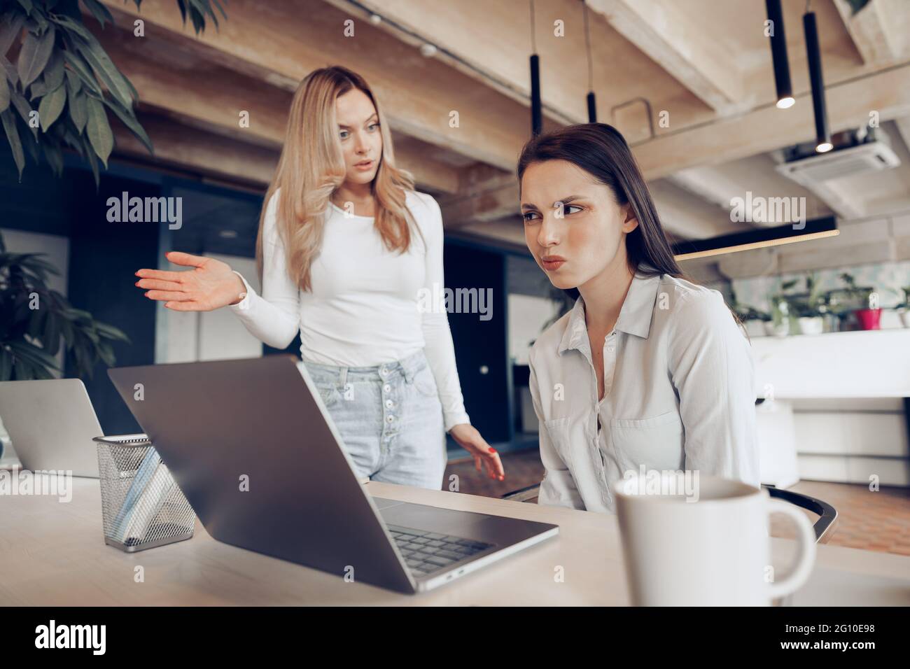 Young female boss scolding her female subordinate for bad work results ...