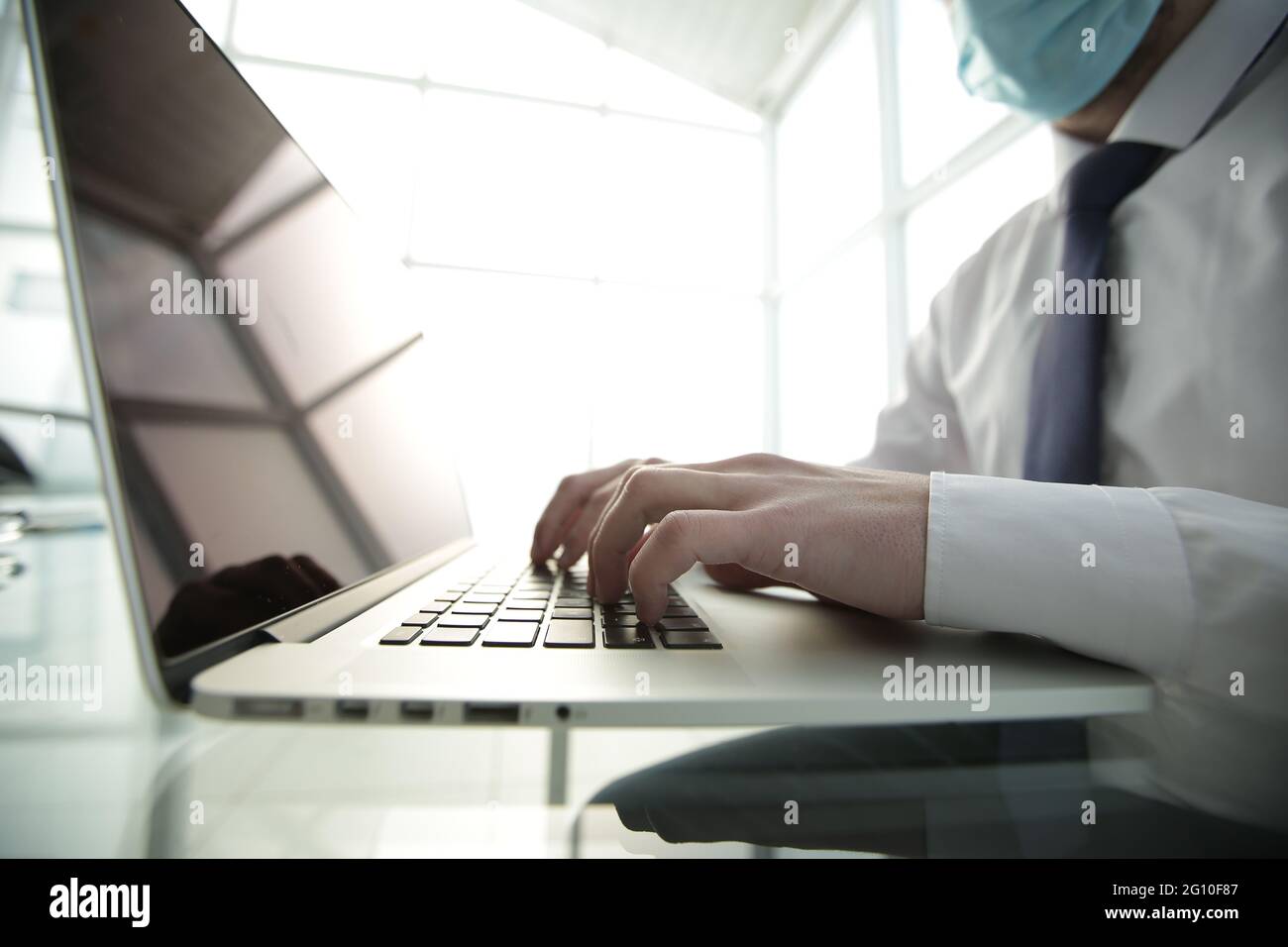 Concentrated young male professional wearing breath protective mask ...