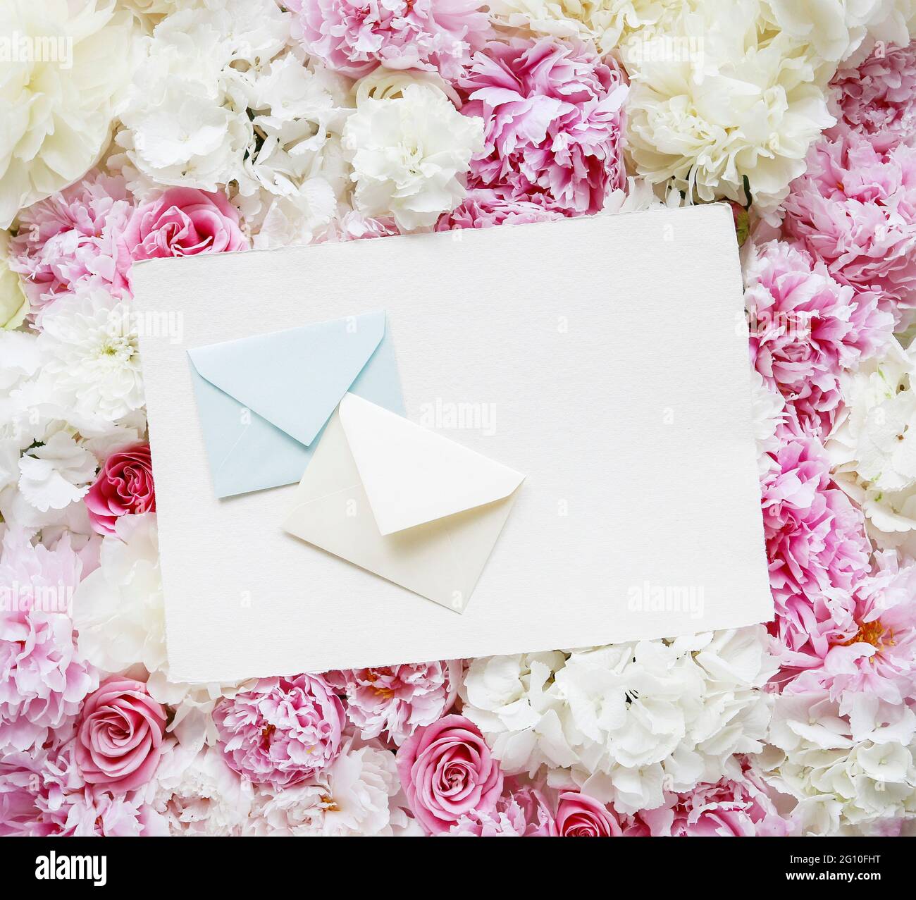 Traditional envelope lying on flower background with peonies, roses and ...