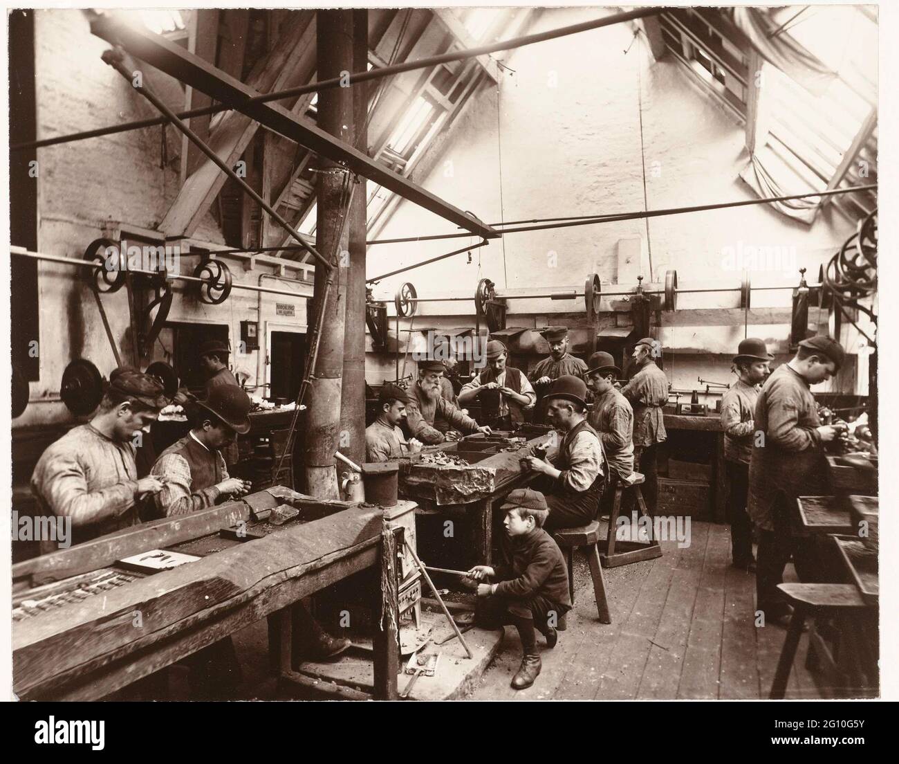 Workers at a workbench in a factory Stock Photo - Alamy
