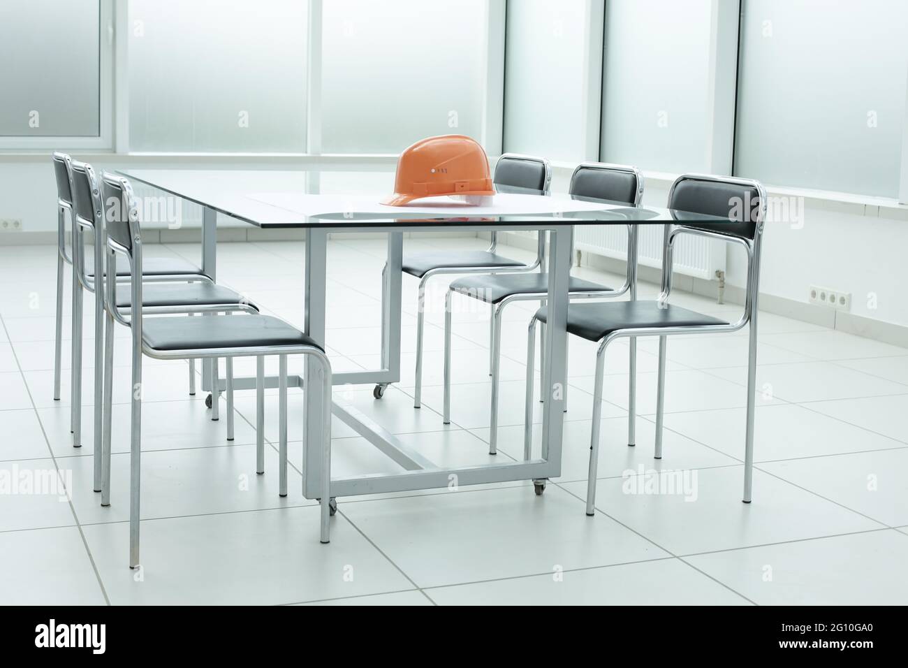 Construction hard hat blueprints on glass table in office space Stock ...