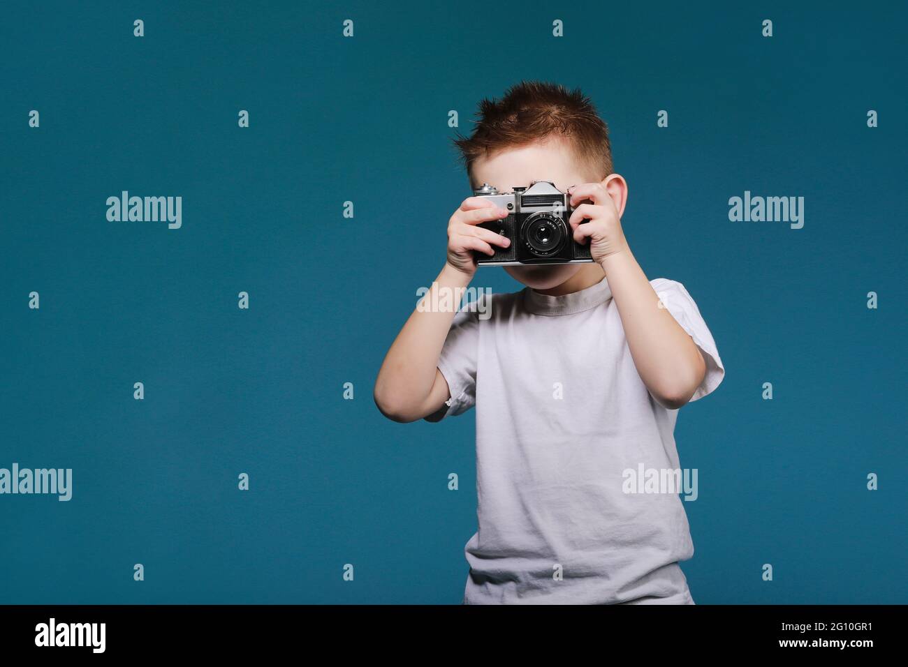 Little boy taking a picture using a retro camera. Child boy with ...