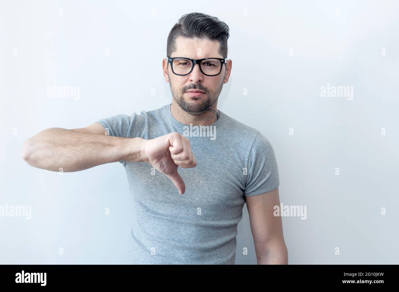 Young man showing thumb down as dislike gesture. Unsatisfied dislike ...