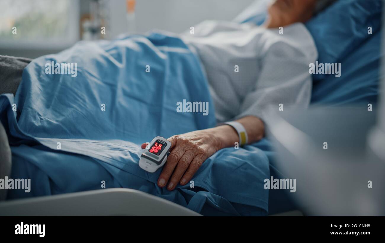 Hospital Ward: Senior Woman Resting in a bed with Finger Heart Rate ...