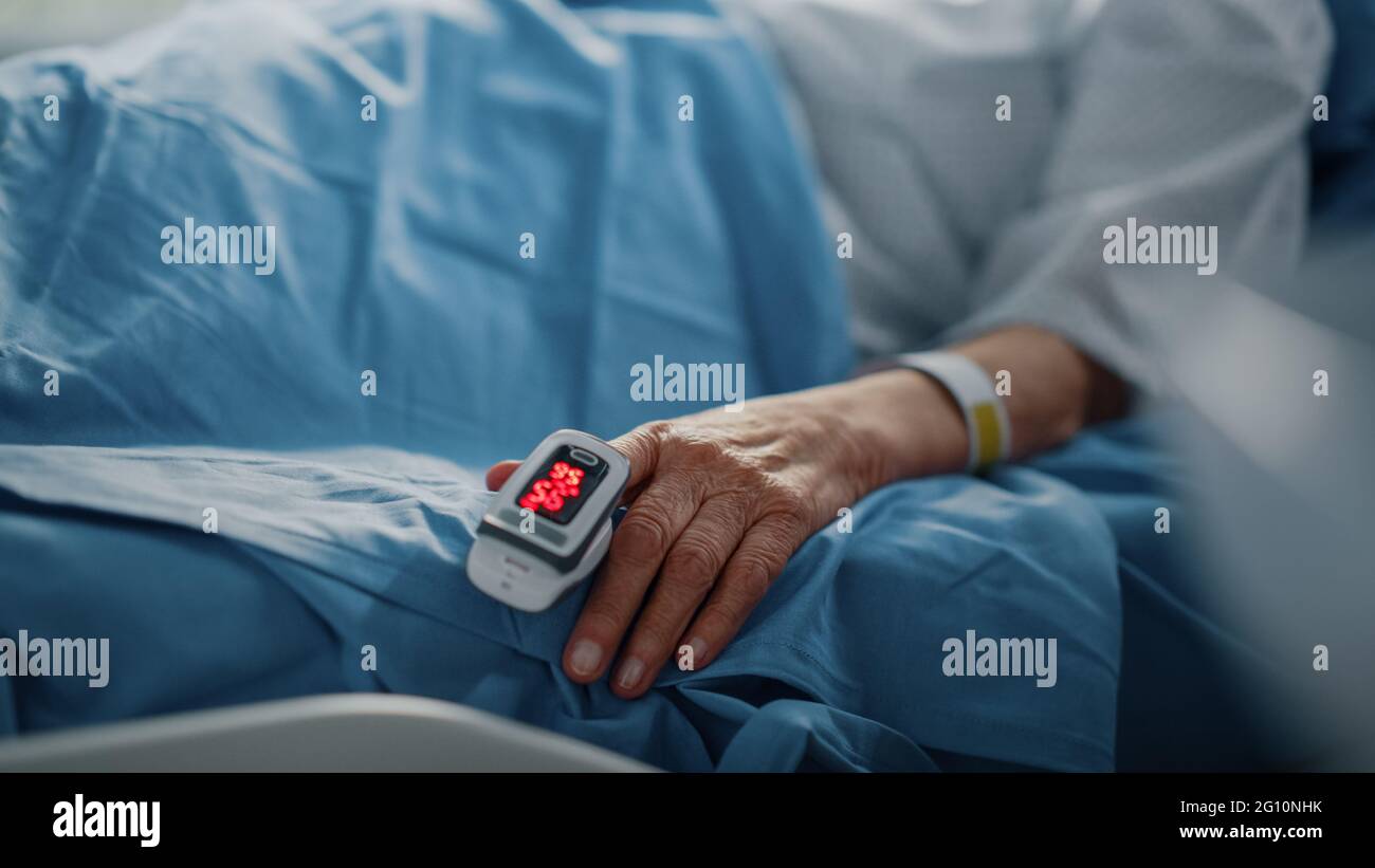 Hospital Ward: Senior Woman Resting in a bed with Finger Heart Rate ...