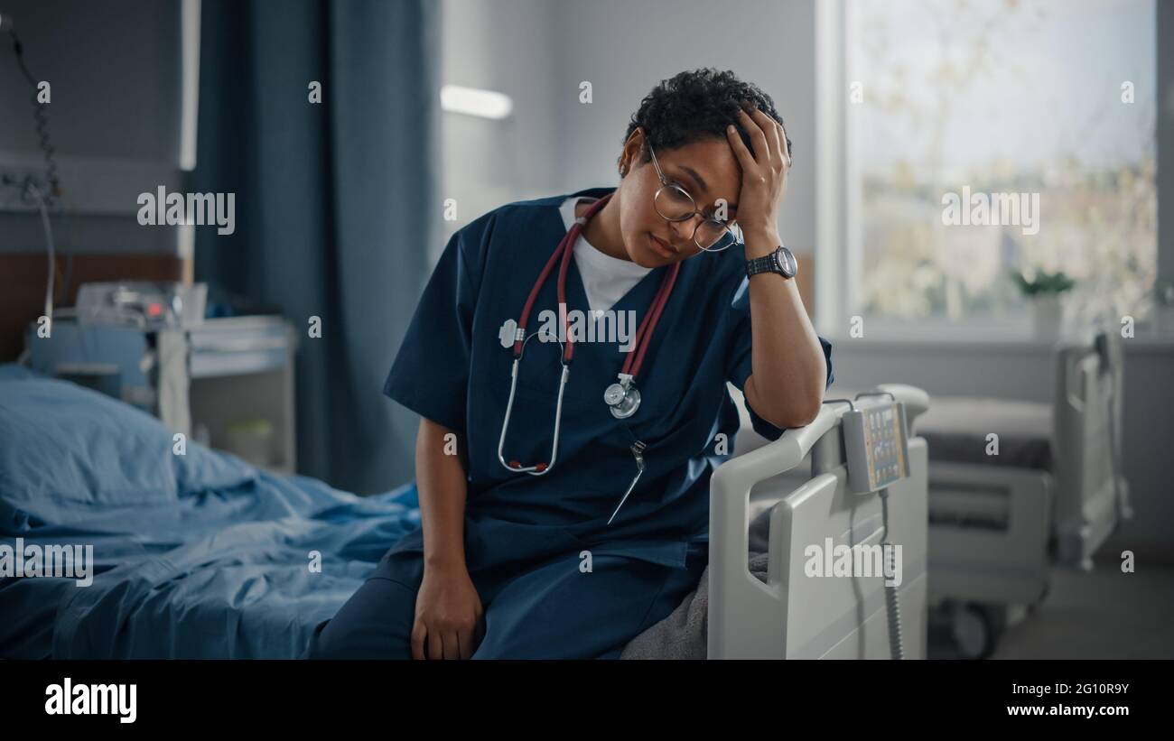 Hospital Ward: Portrait of Sad, Tired Black Nurse Sitting on a Bed ...