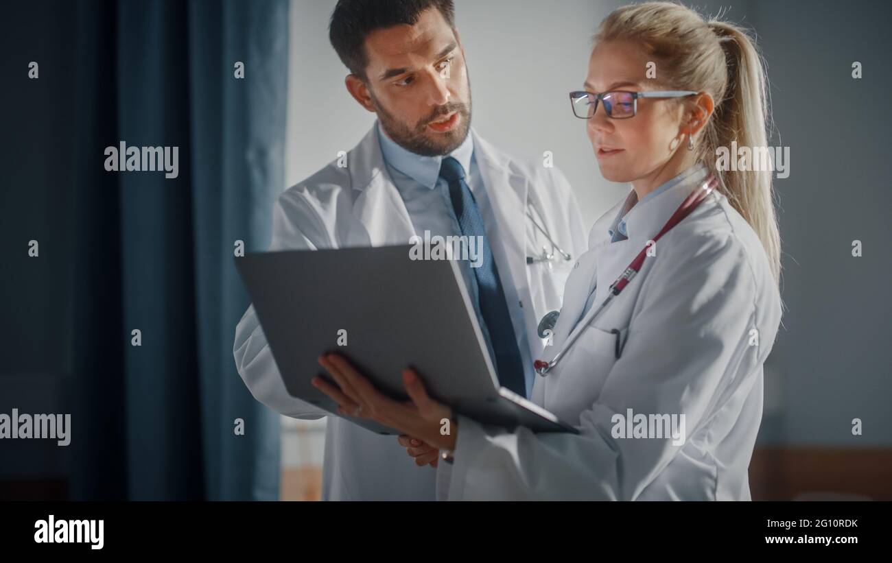 Hospital Ward: Male and Feamle Professional Doctors Hold Laptop ...