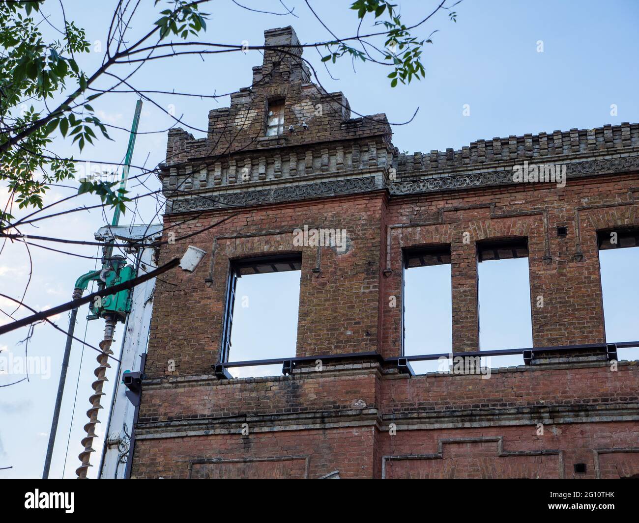 Exterior red-brick walls of an ancient half-ruined building with ...
