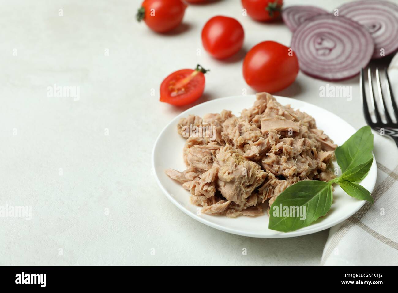 Concept of tasty eating with canned tuna on white textured background ...
