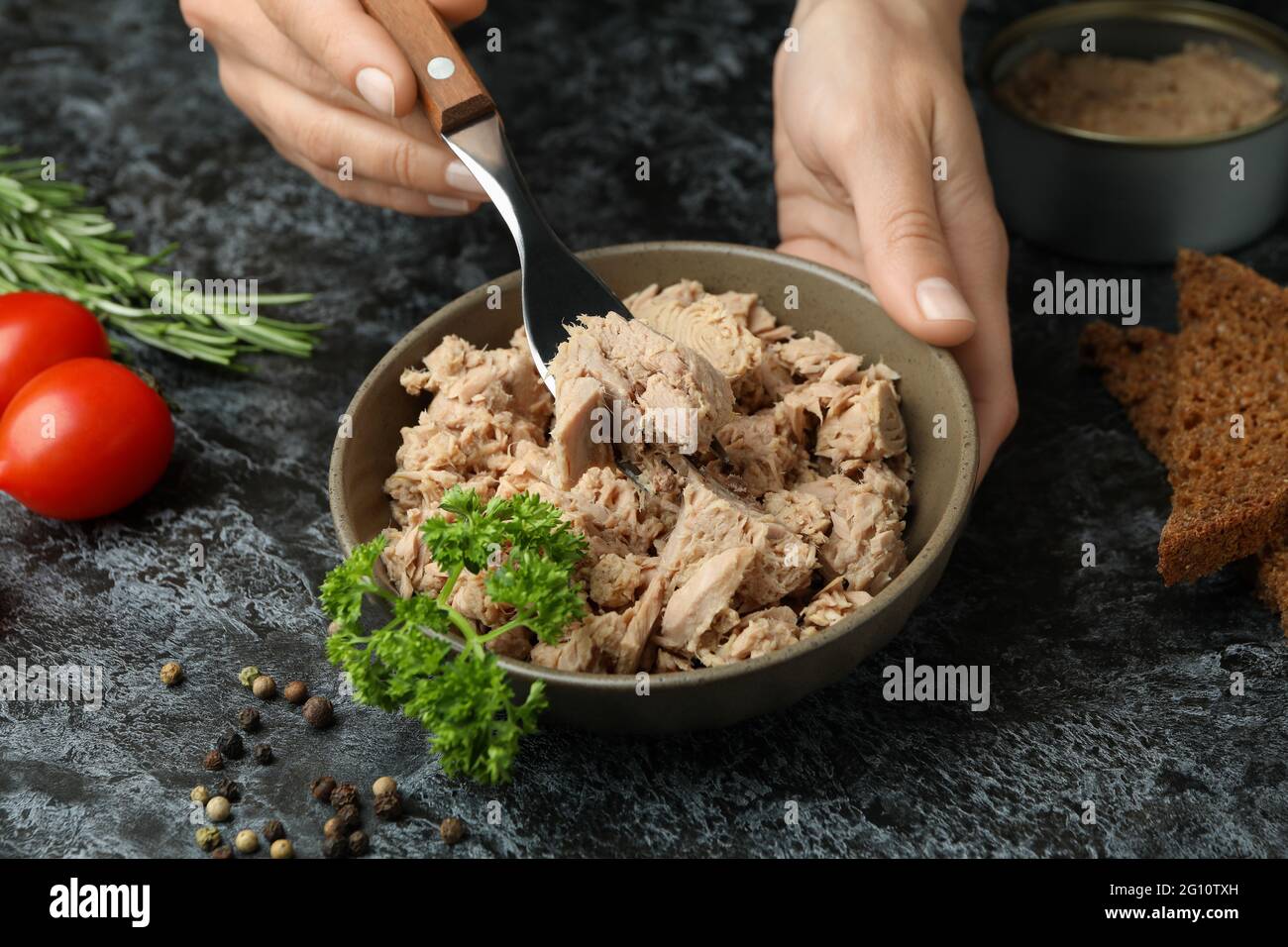 Concept of tasty eating with canned tuna on black smokey background ...