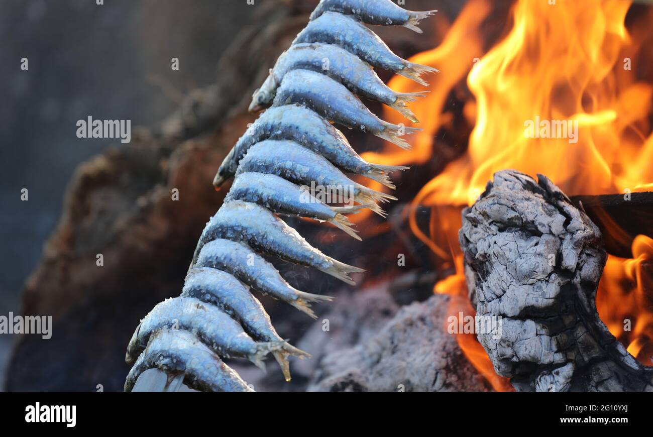 fish spit on fire, beach background Stock Photo - Alamy