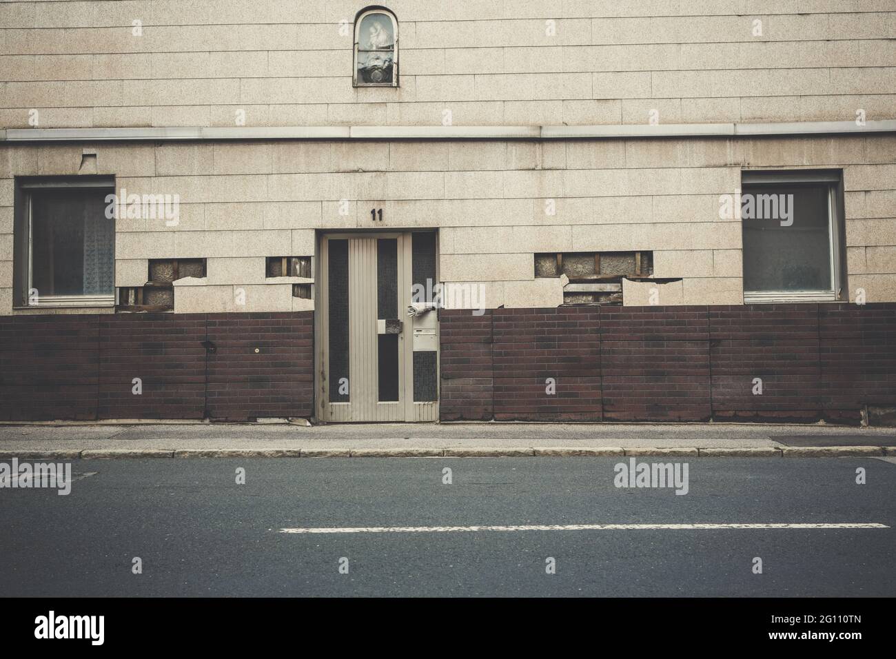 Facade of a beige and brown old building with defective walls near the ...