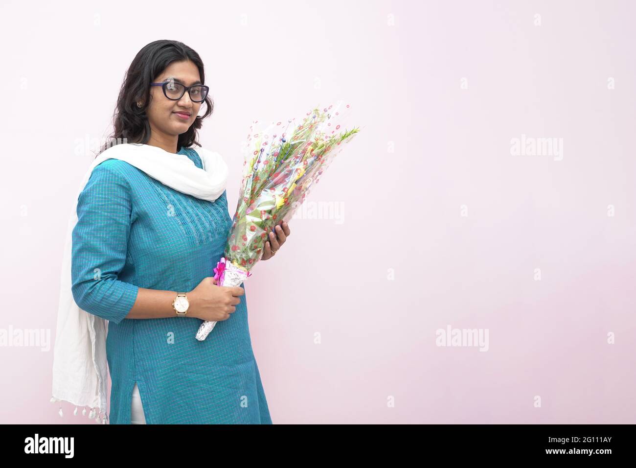 Beautiful South Asian female posing with a bouquet on a white ...