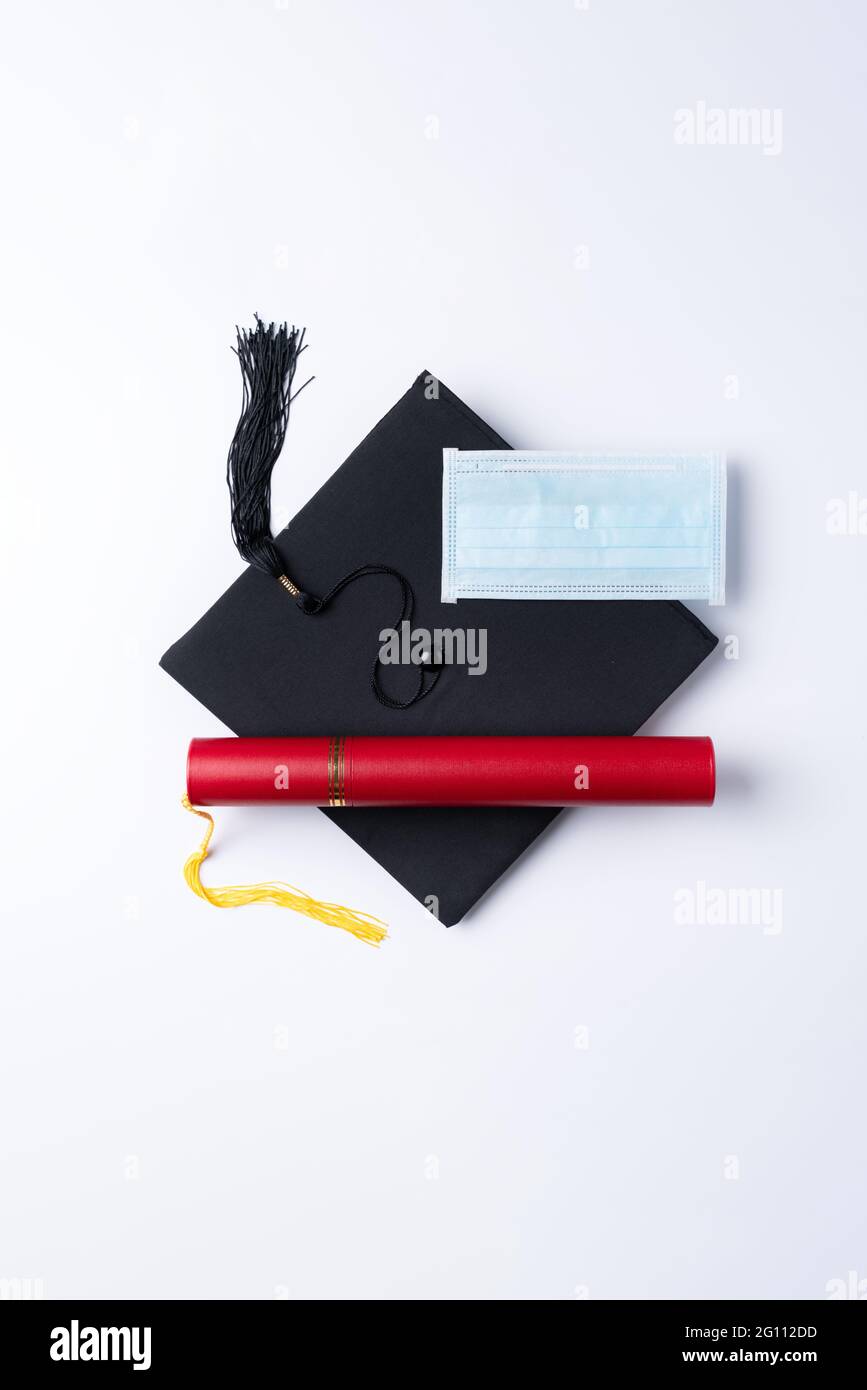 Top view of graduation square academic cap with degree diploma and mask ...