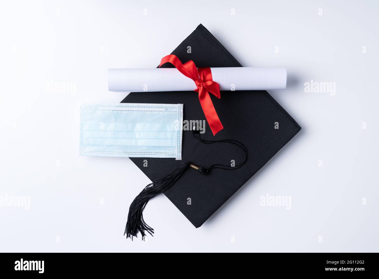 Top view of graduation square academic cap with degree diploma and mask ...