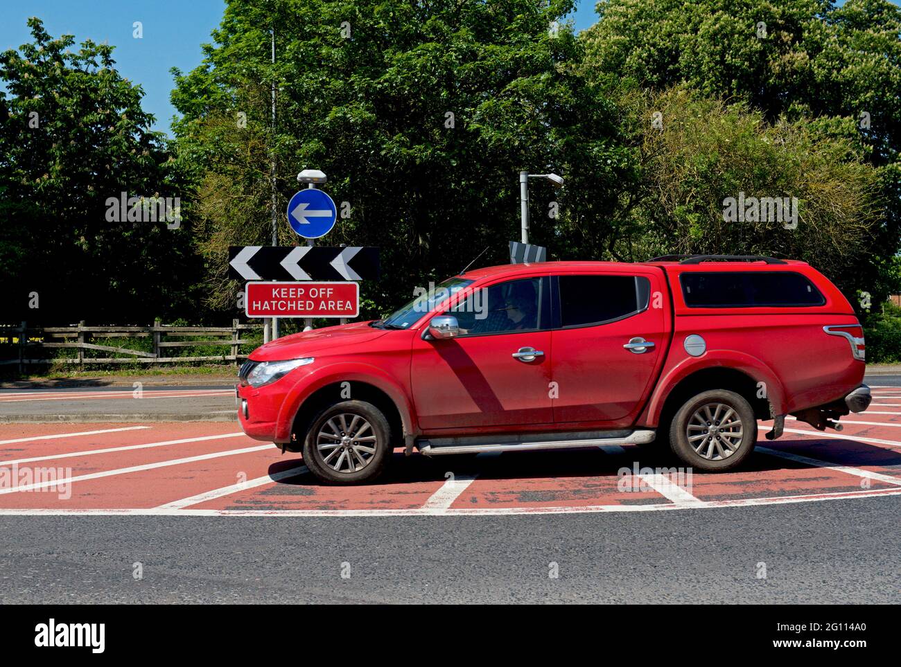 Car on roundabout, crossing hatched lines, England UK Stock Photo - Alamy