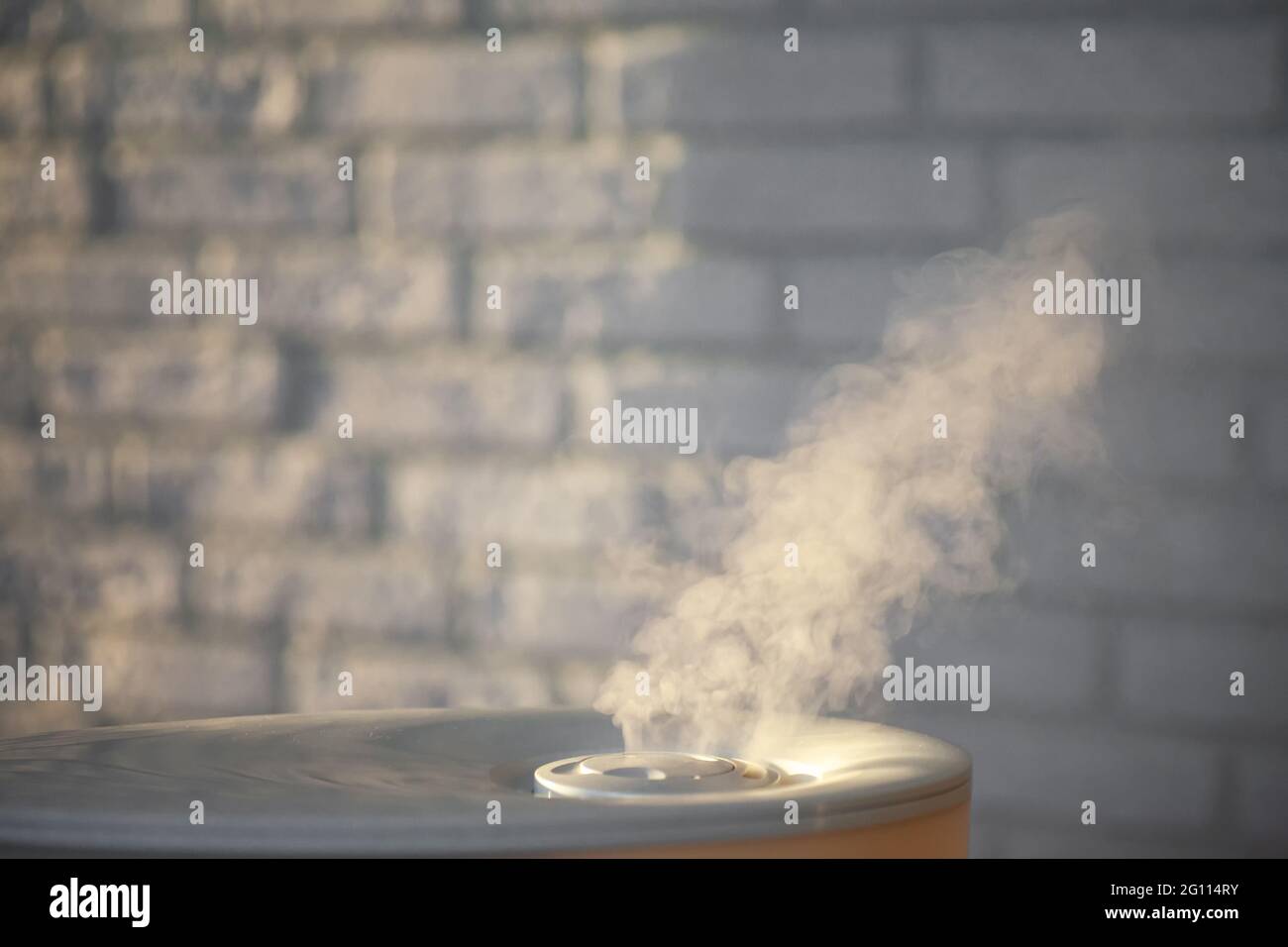 Humidifier spreading steam with white brick wall background. Loft style ...