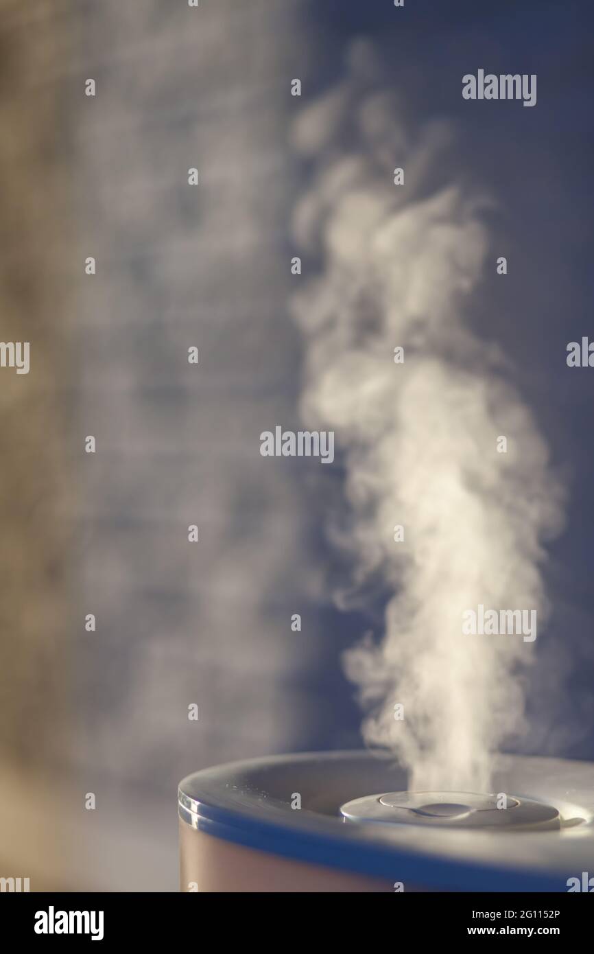 Humidifier spreading steam with white brick background. Loft style ...