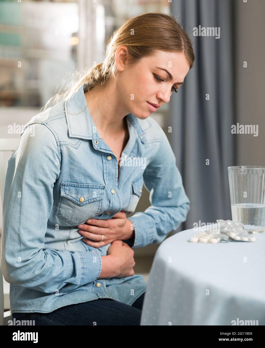 Young woman experiencing pain in the stomach Stock Photo - Alamy