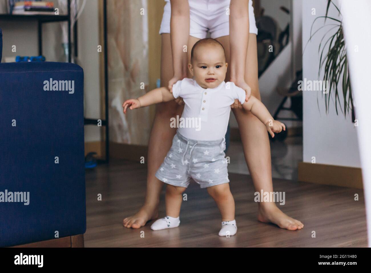 First steps of baby boy. Little child learning how to walk. Mother ... First steps of baby boy. Little child learning how to walk. Mother ...