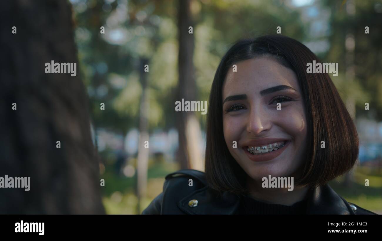 Young girl wooing her lover behind the tree. Smiling young cheerful ...