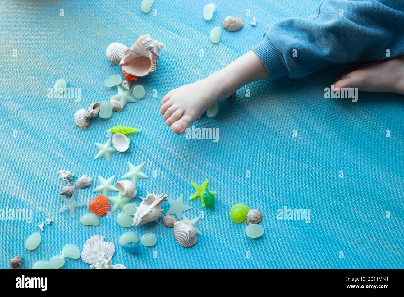 baby feet on Seashells summer background. Many different seashells ...