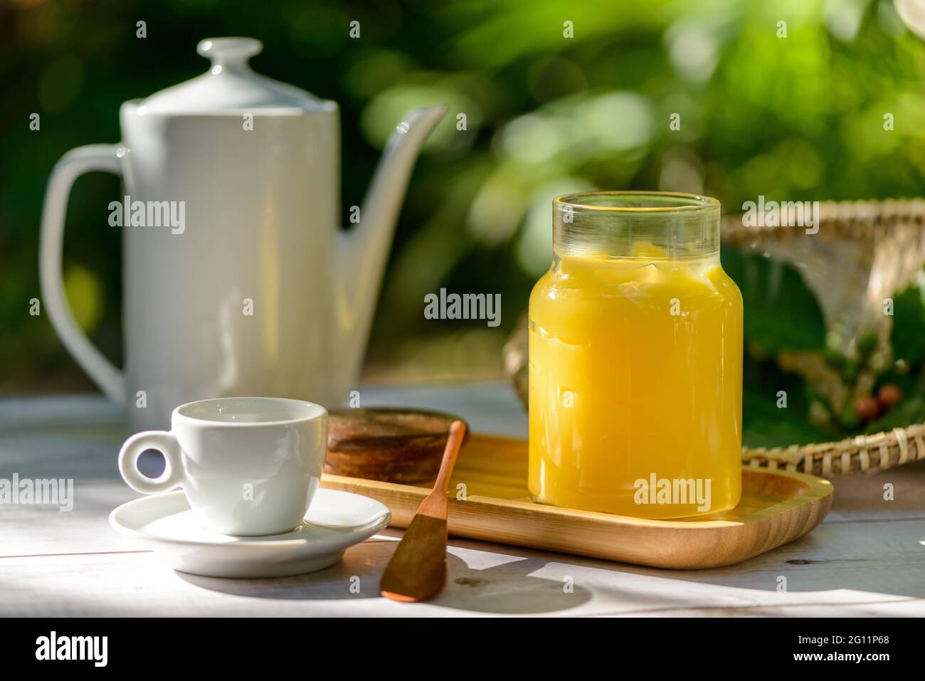 Ghee butter in glass jar on breakfast table with white teapot and cup ...
