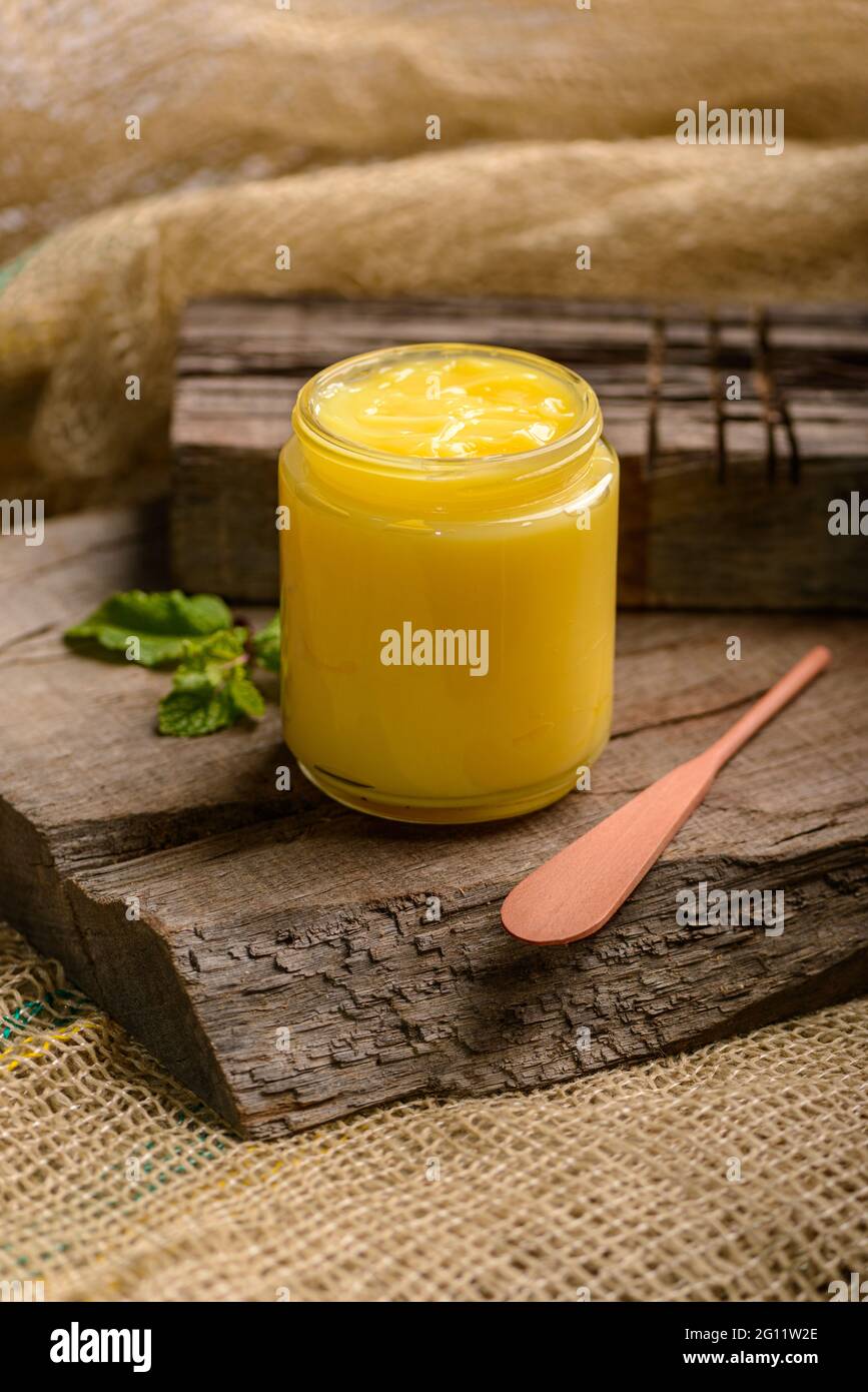 Ghee butter in glass jar with wooden spatula on wood Stock Photo - Alamy