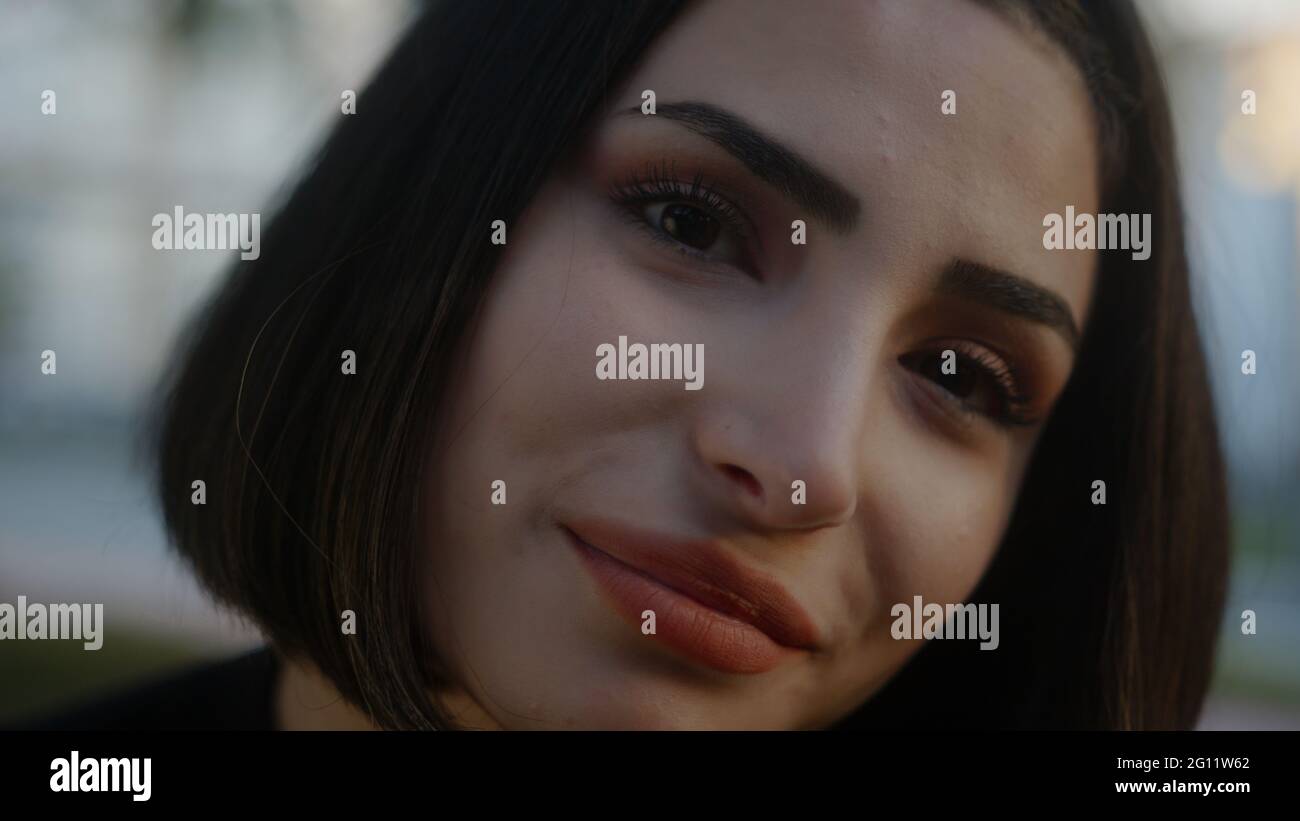Close up portrait of a young woman on the park happy eyes looking into ...