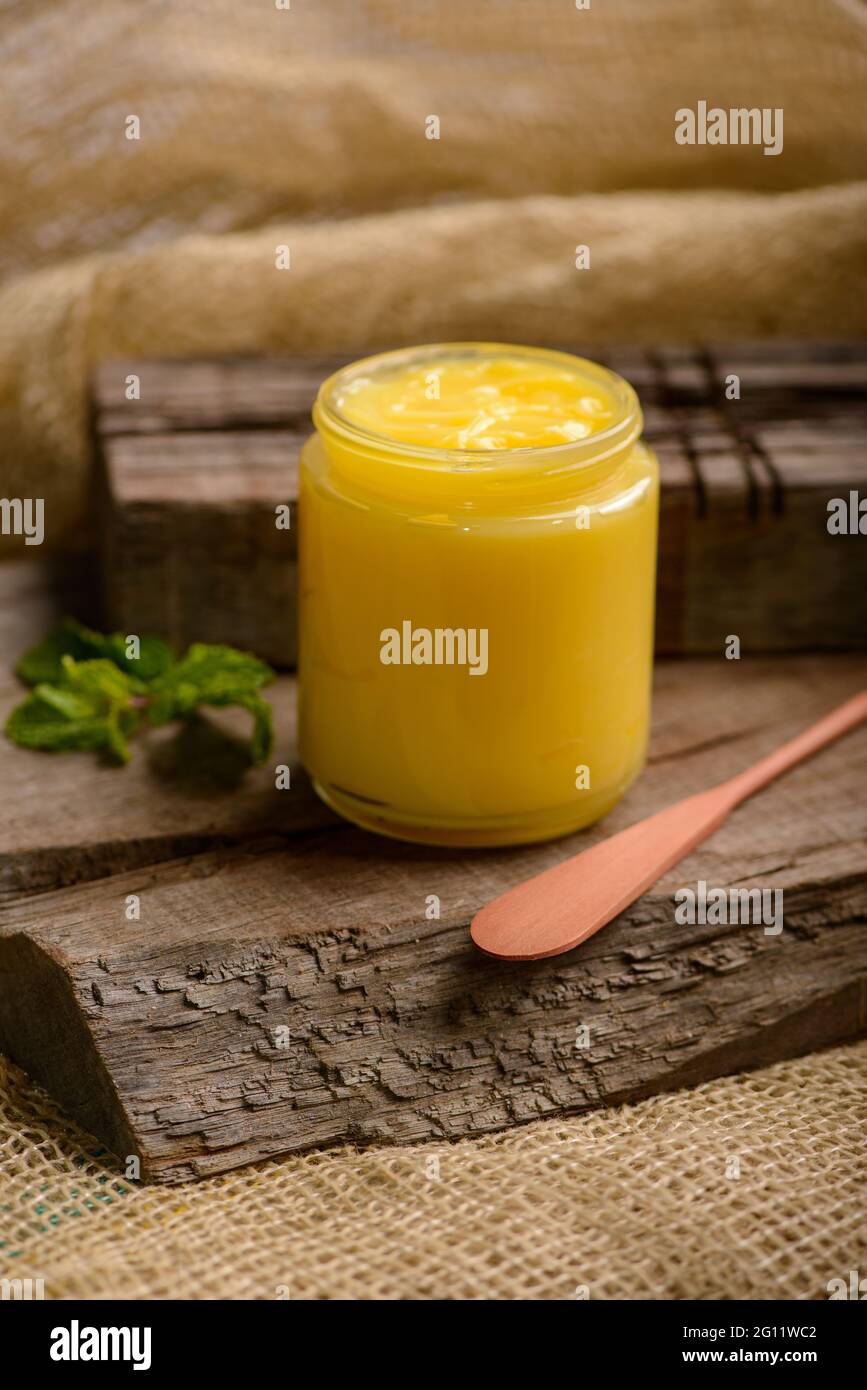 Ghee butter in glass jar with wooden spatula on wood Stock Photo - Alamy