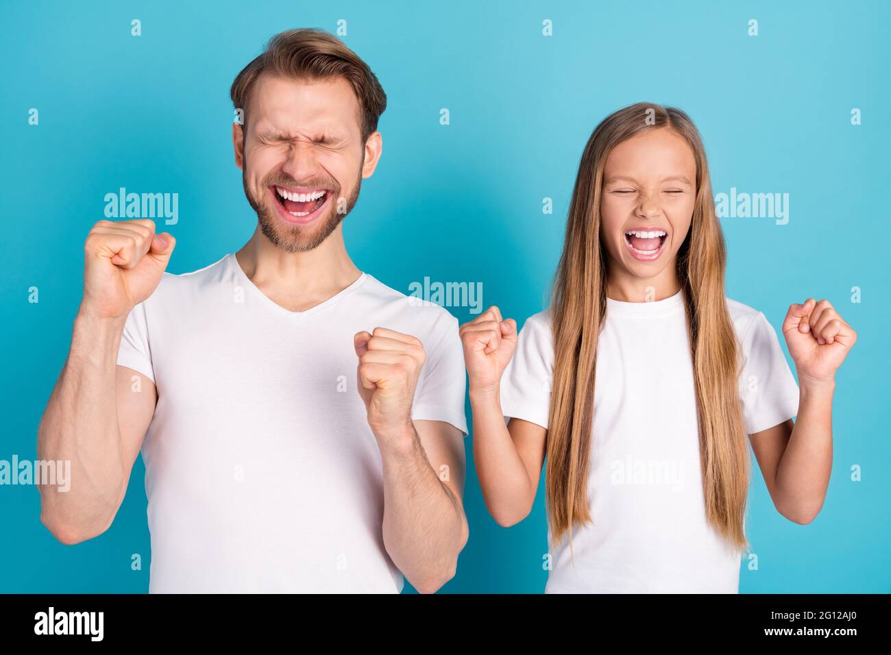 Portrait of two delighted positive persons closed eyes fists up open ...