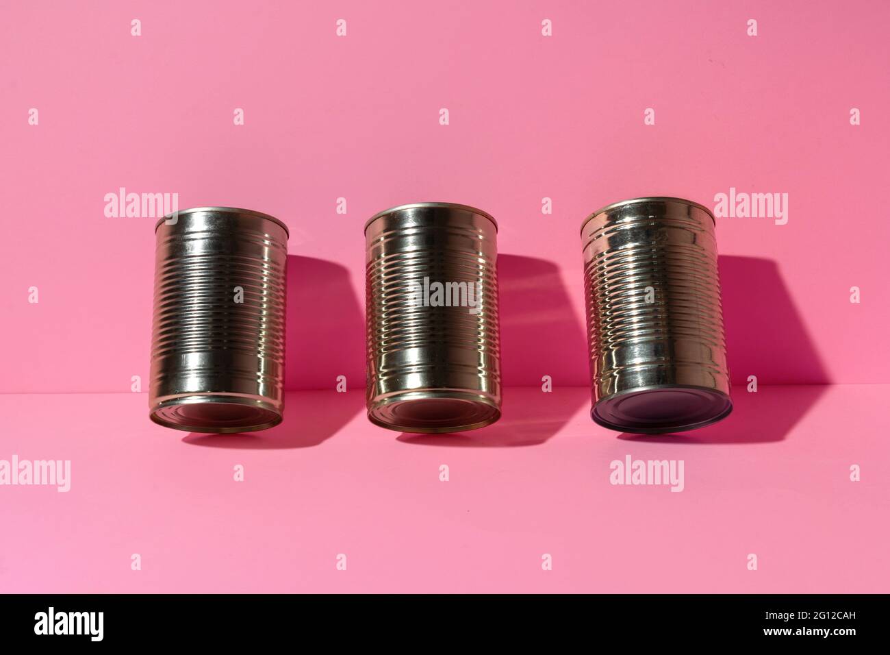 Canned food tin on pink studio background Stock Photo - Alamy