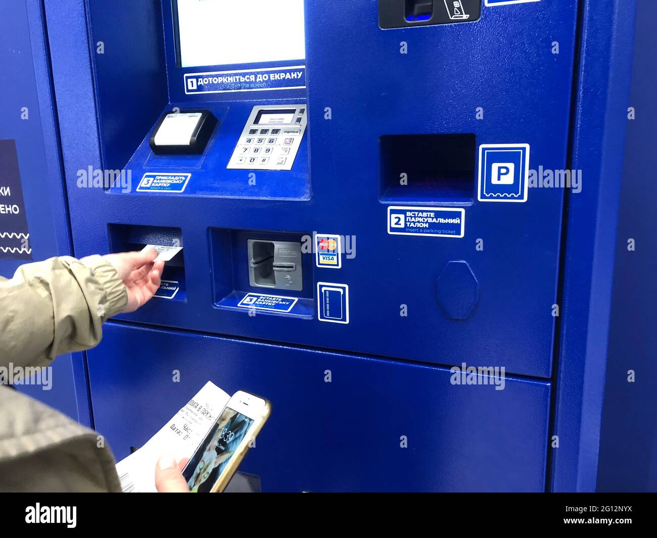 A driver paying parking fee in pay station, ATM paid parking. A person ...