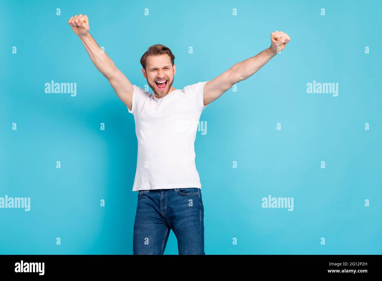 Photo of satisfied young man raise arms fists open mouth scream yes ...