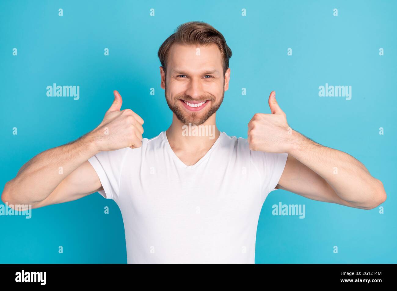 Portrait of satisfied friendly young man shot two thumbs up beaming ...