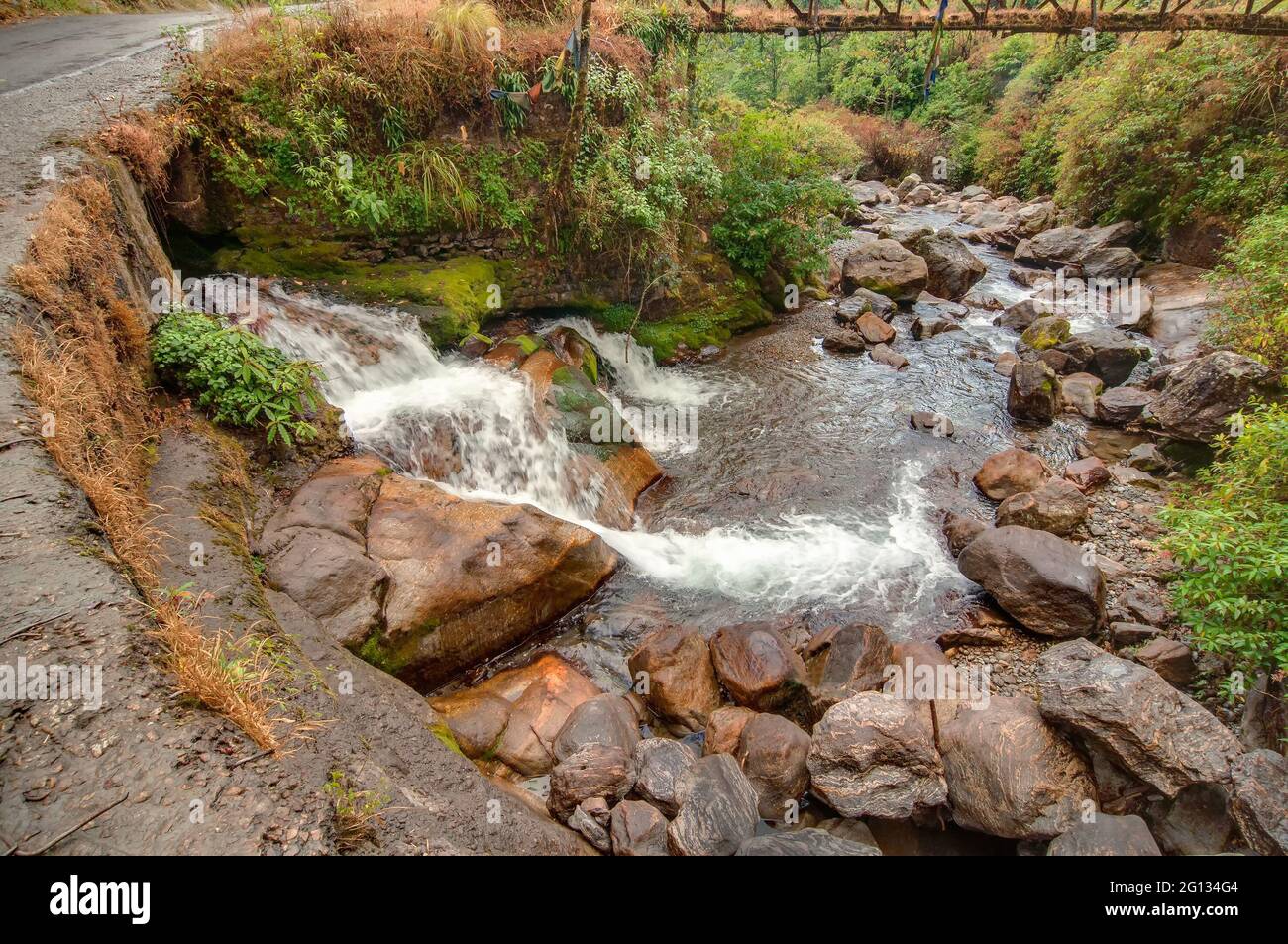 Fountain water flowing through rocks with green plants around, Kukhola ...