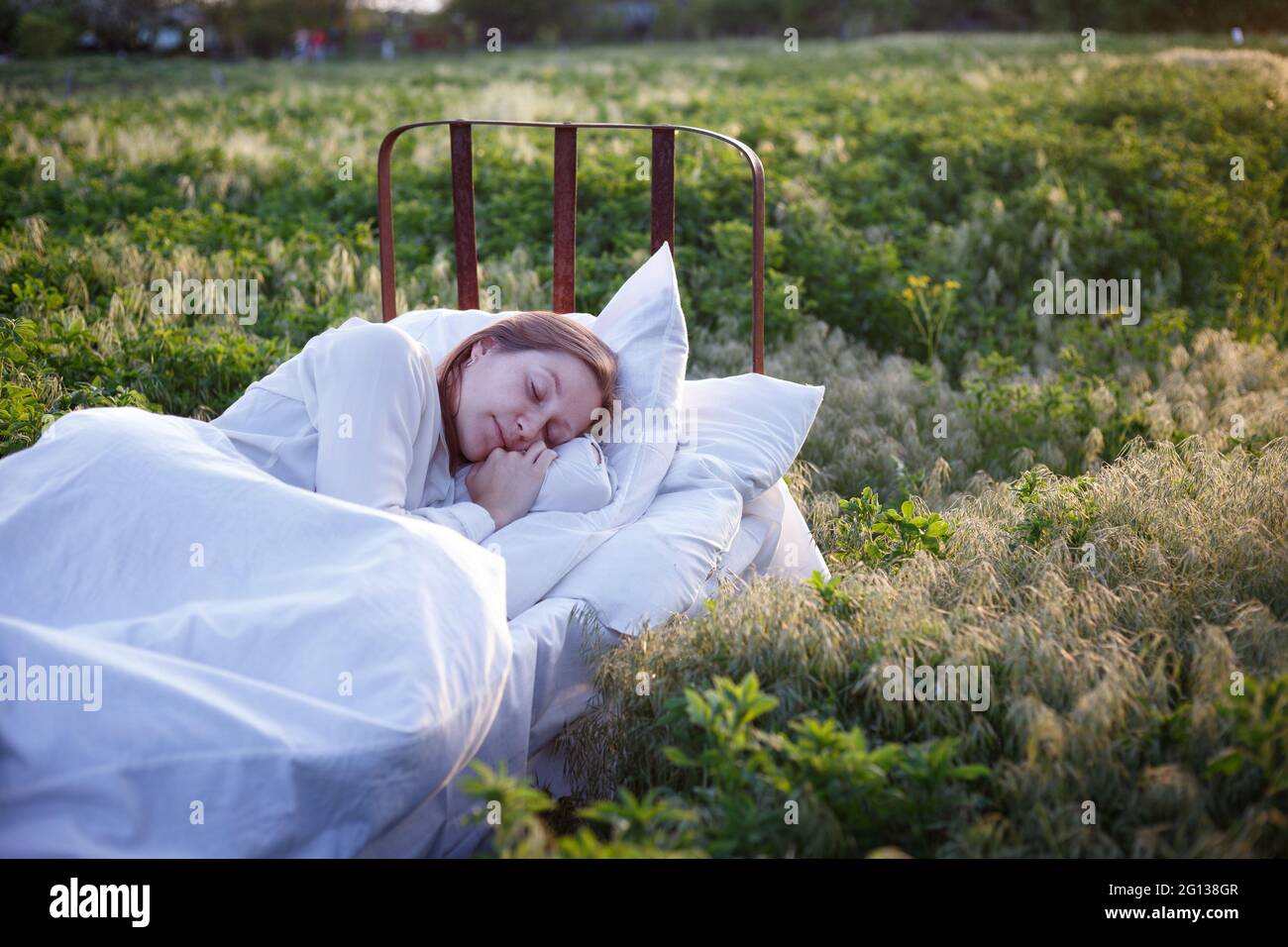 girl sleeping in the bed in a green field. healthy sleep in nature ...