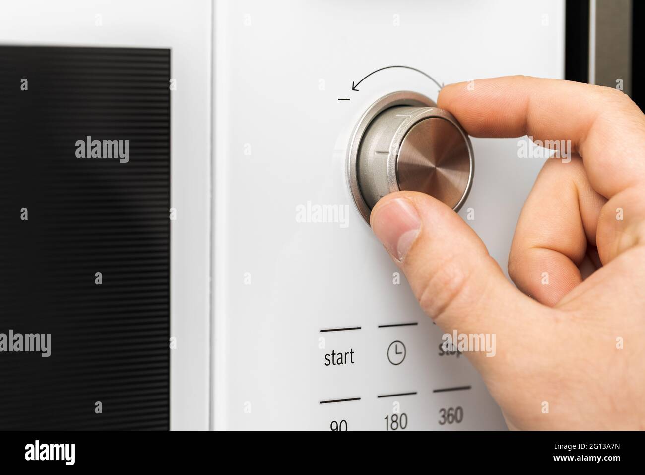 Hand pushing button of microwave oven for cooking food in kitchen Stock ...