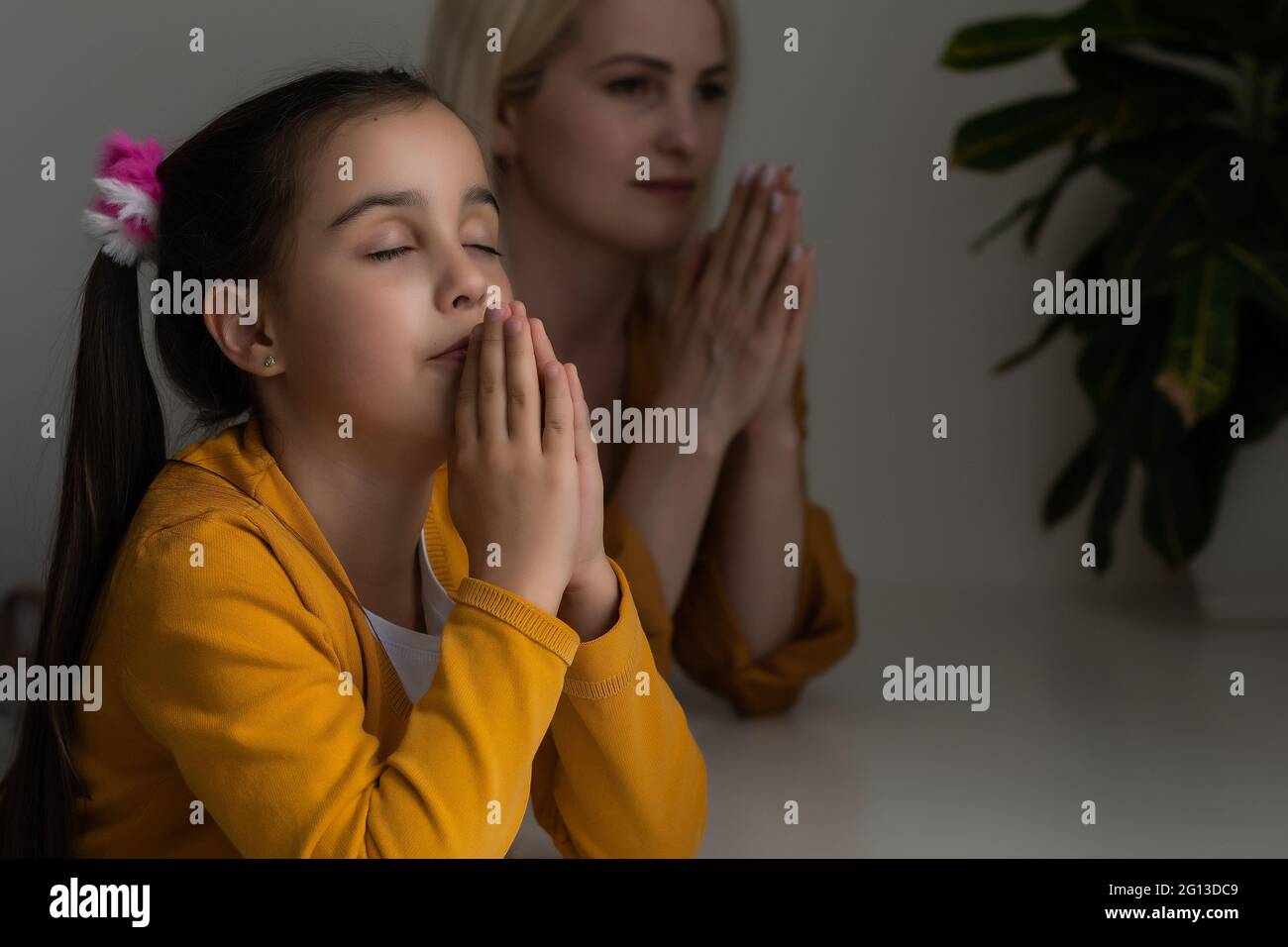 Religious Christian girl and her mother praying at home Stock Photo - Alamy