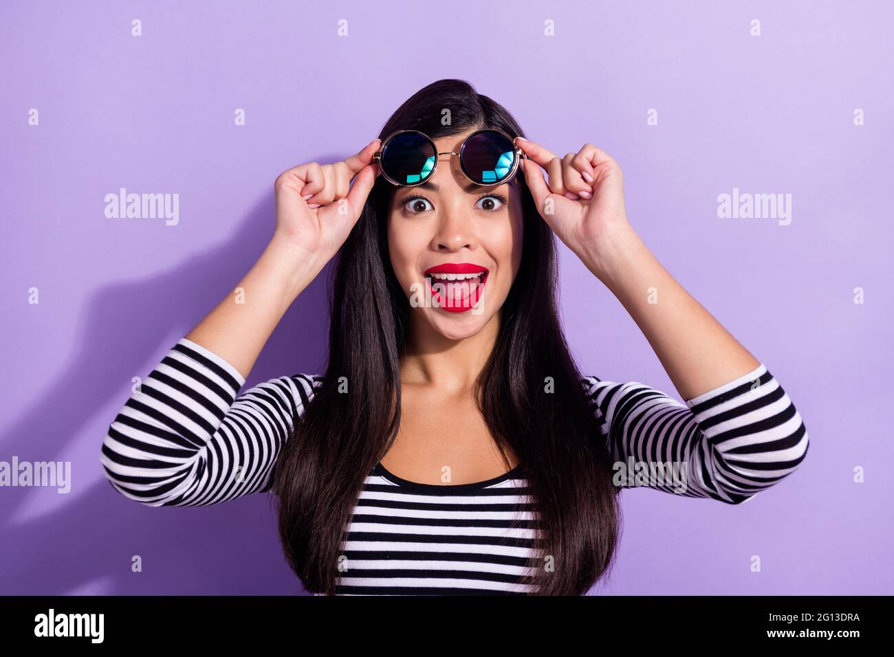 Photo of pretty shocked young lady wear striped shirt arms dark eyewear ...