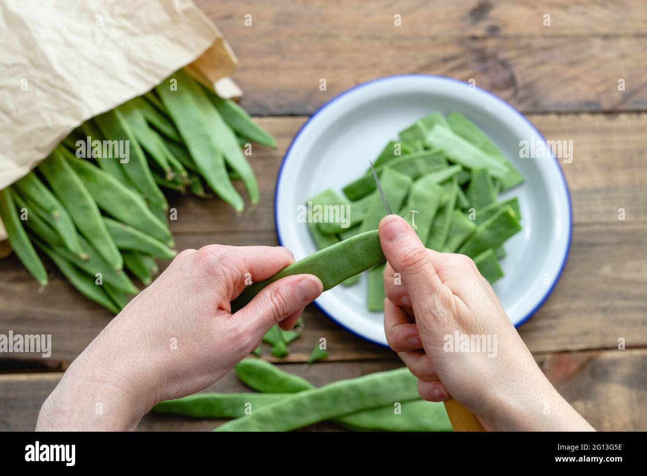 Woman's hand cutting green beans for cooking. Food preparation concept ...