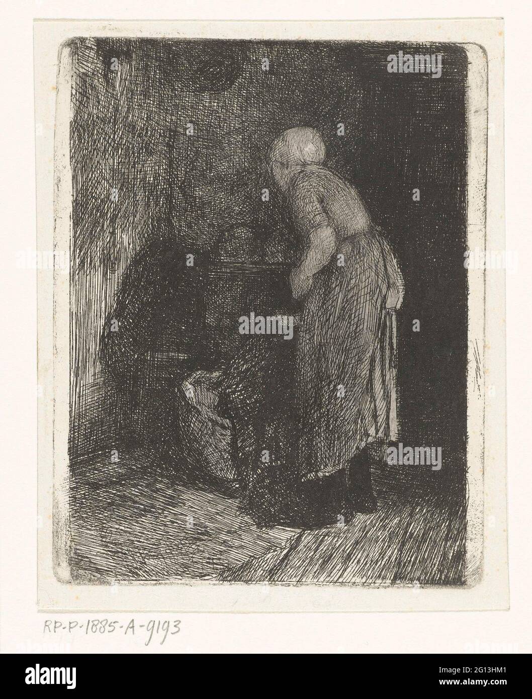 Woman looks into a cradle Stock Photo - Alamy