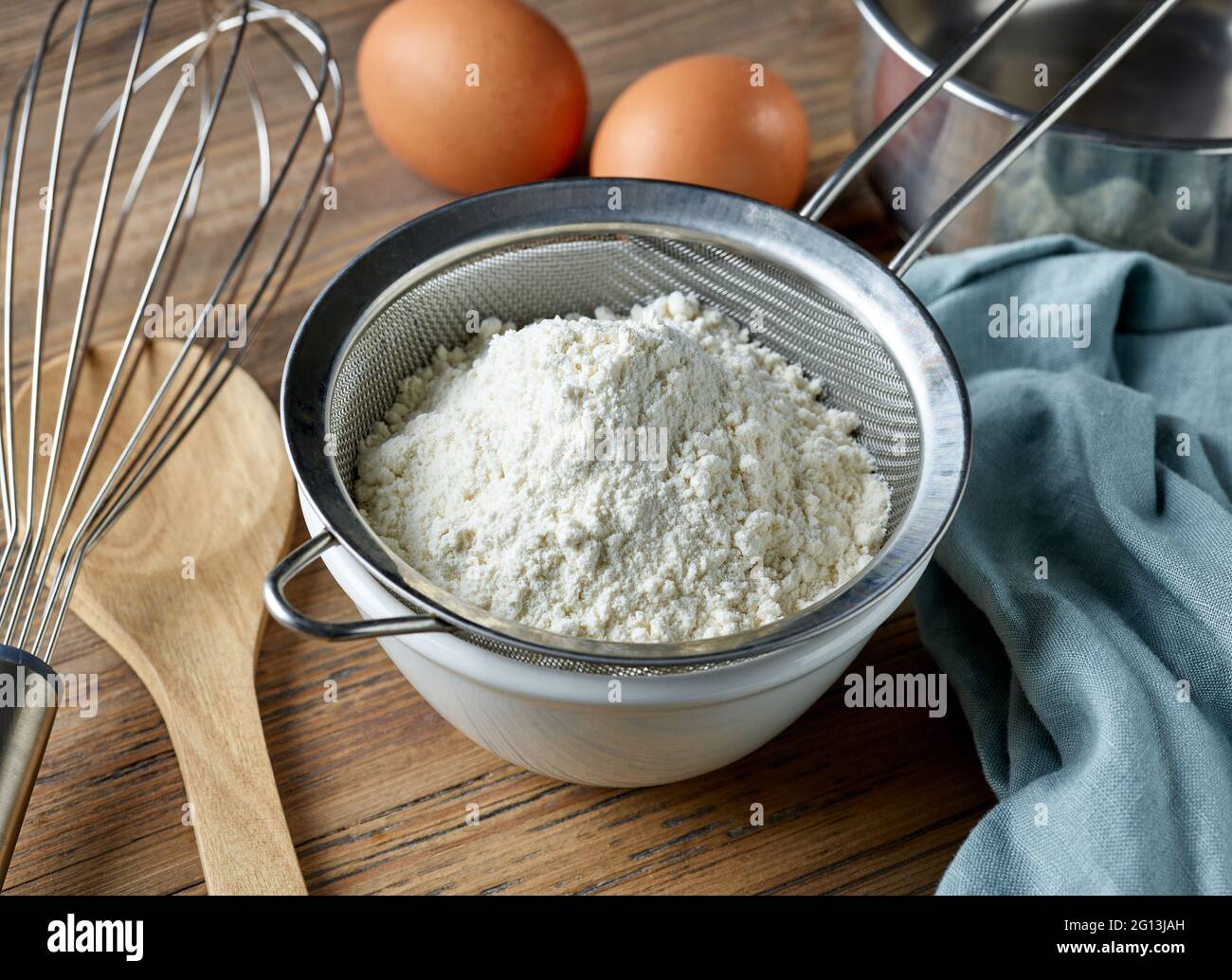 bowl and flour in strainer on kitchen table for making dough Stock ...