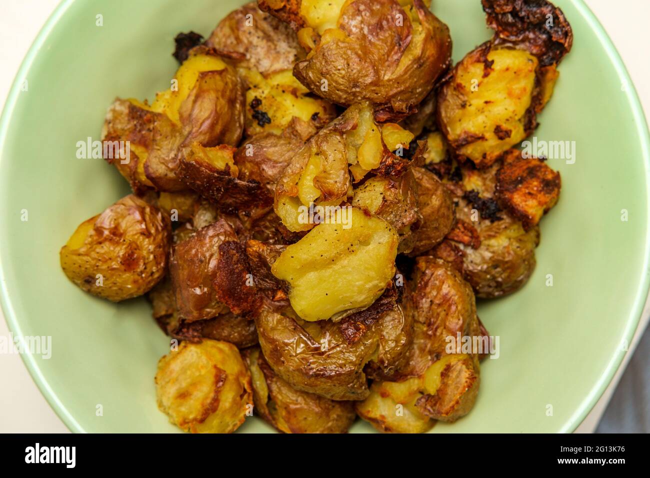 Baked smashed potato home-fries in server bowl Stock Photo - Alamy